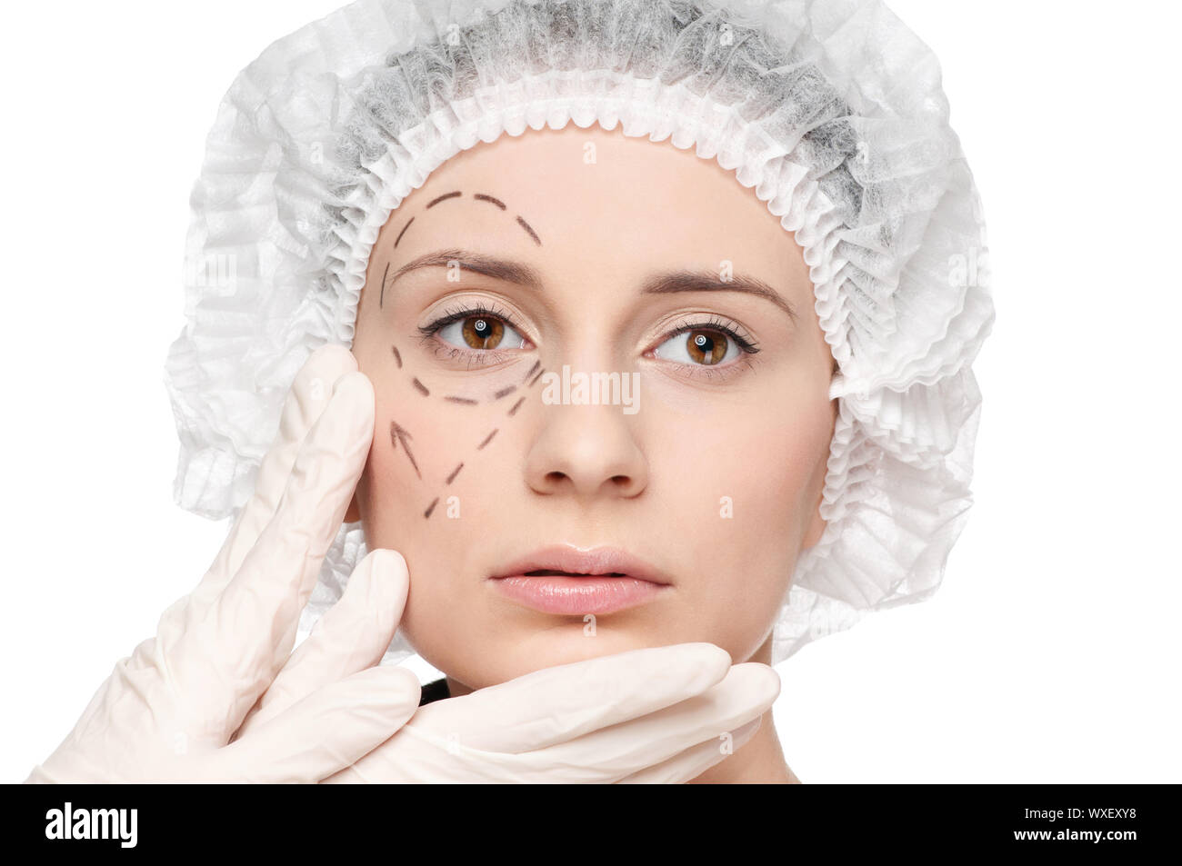 Beautician touch and draw correction lines on woman face. Before plastic surgery operetion ...
