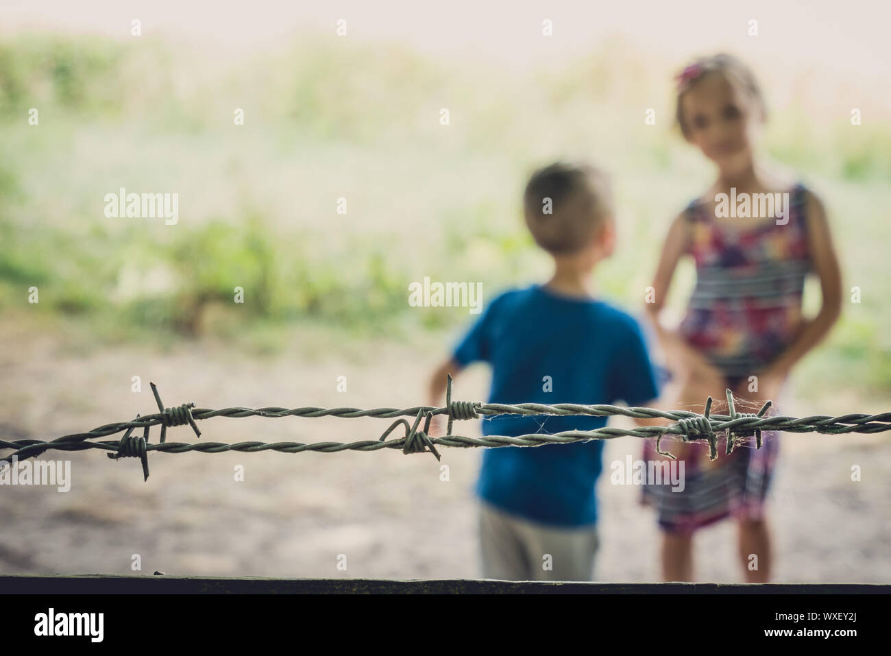 Kids behind berbed wire Stock Photo - Alamy
