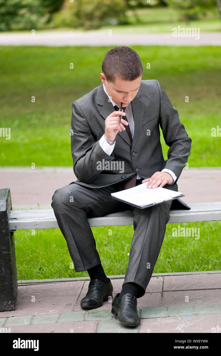 Young business man waiting for meeting, working with papers at green ...