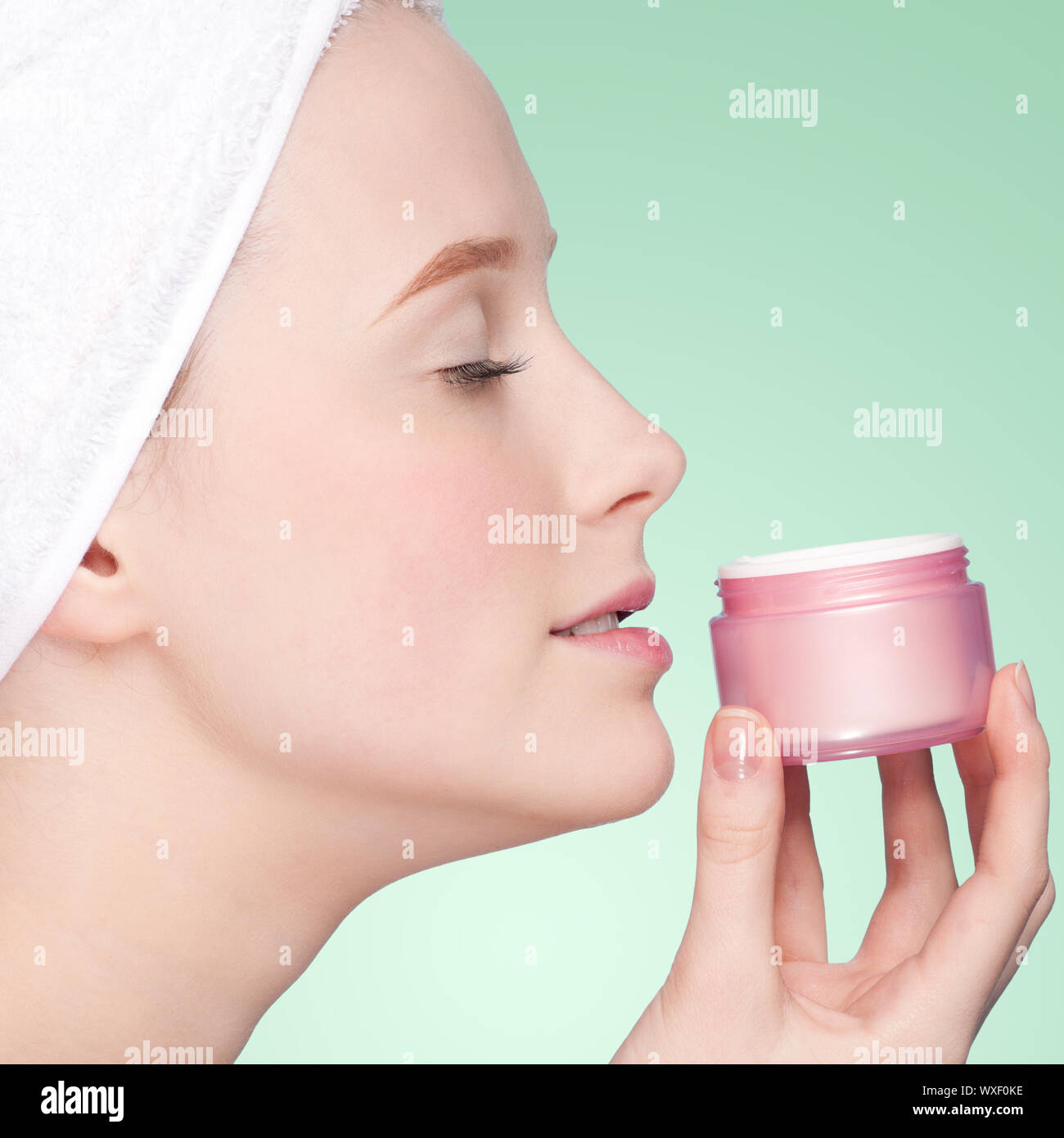 Beautiful woman smell jar of moisturizer cream. Close-up fresh young ...
