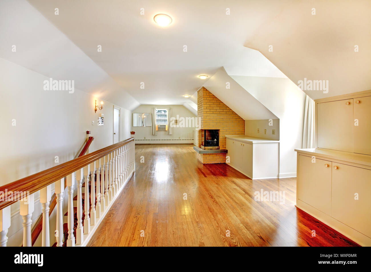 Large long attic room with fireplace. Empty with golden hardwood Stock ...