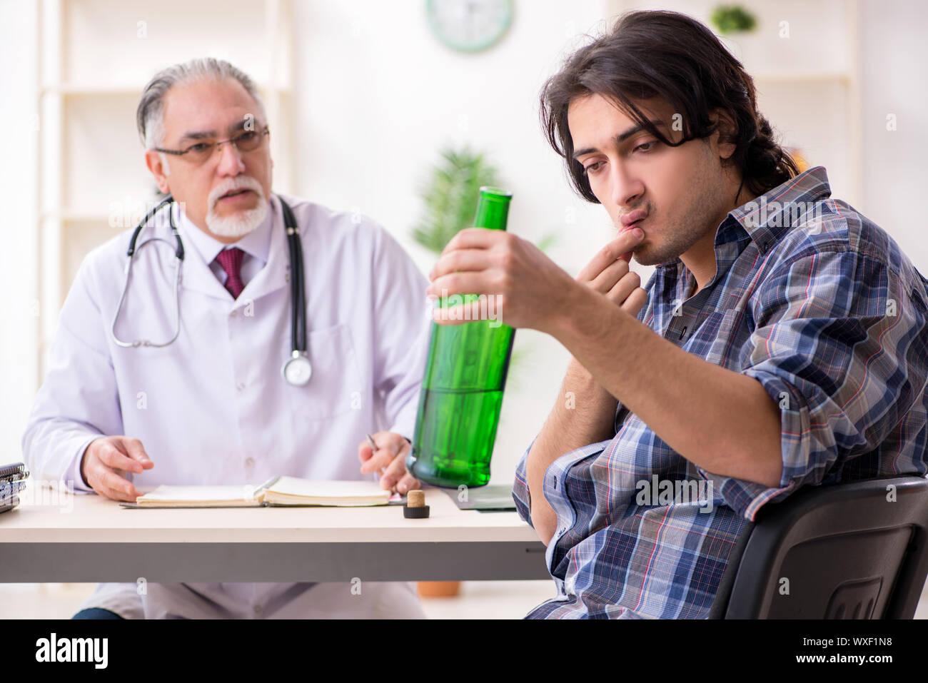 Young male alcoholic visiting old doctor Stock Photo - Alamy