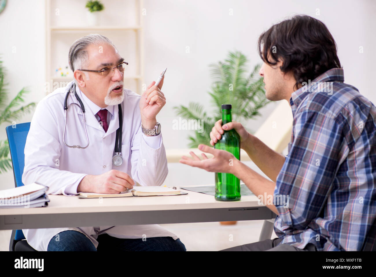 Young male alcoholic visiting old doctor Stock Photo - Alamy