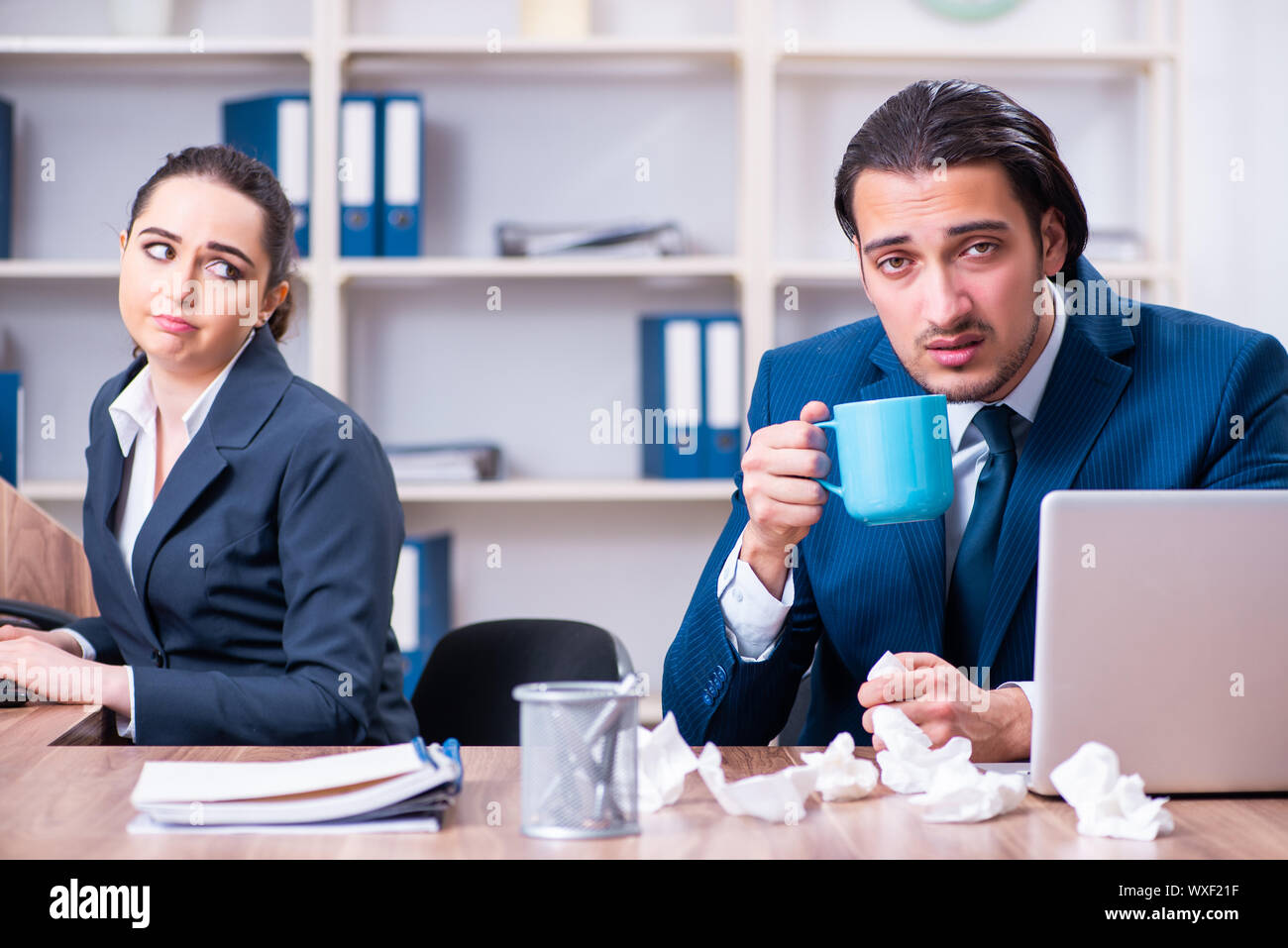 Two employees suffering at workplace Stock Photo - Alamy