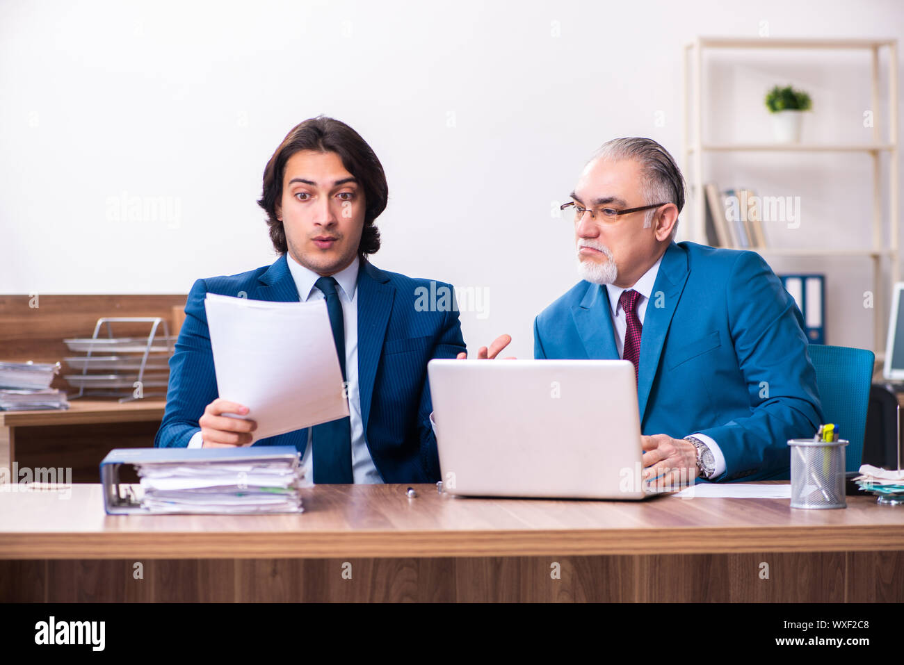 Young and old employees working together in the office Stock Photo - Alamy