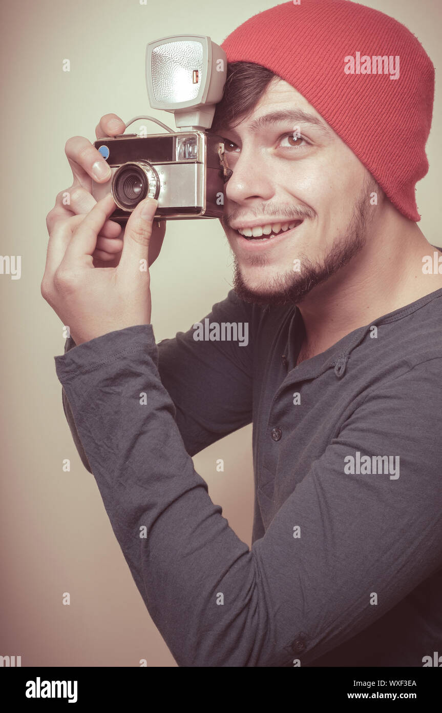young stylish man holding old camera on vignetting background Stock ...