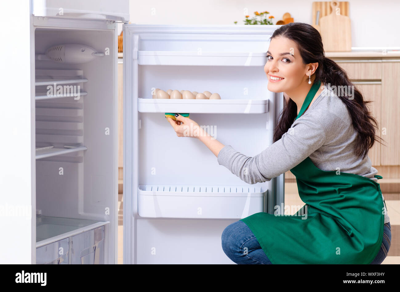Young woman cleaning fridge in hygiene concept Stock Photo - Alamy