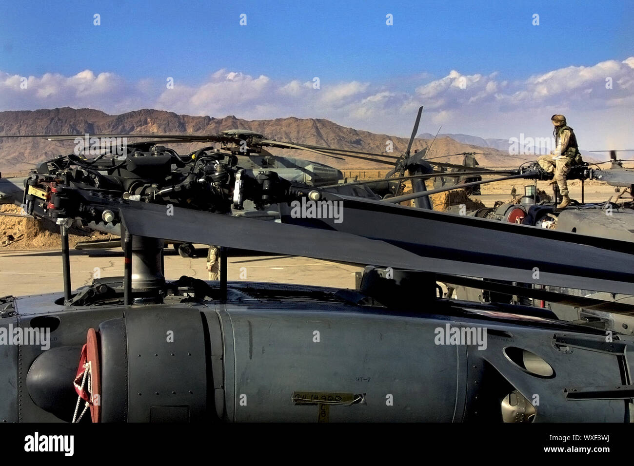 A U.S. Army soldier sits on the rotor blades of a UH-60 Blackhawk ...