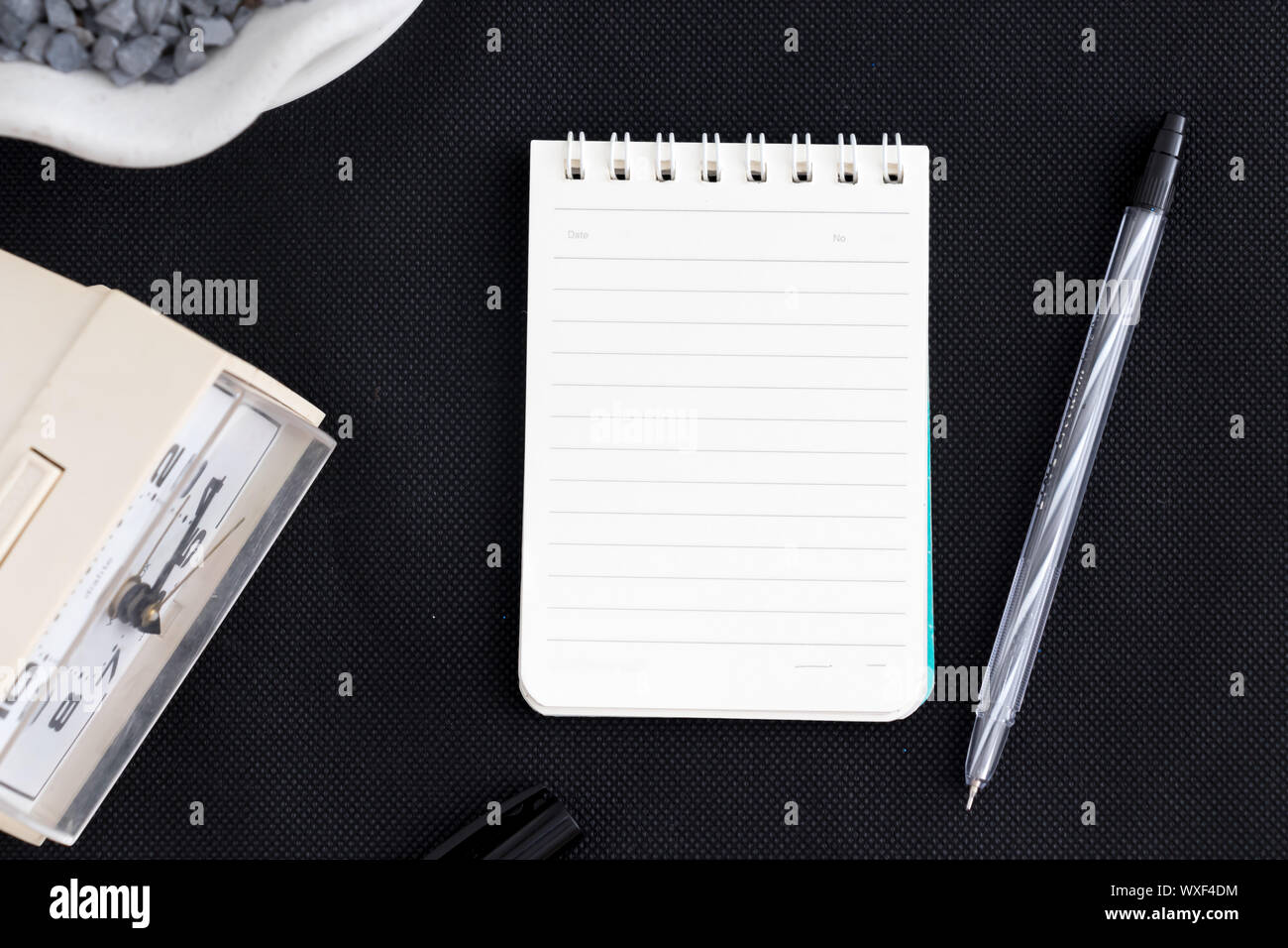 Black office desk with notebook and pen office plant Stock Photo - Alamy