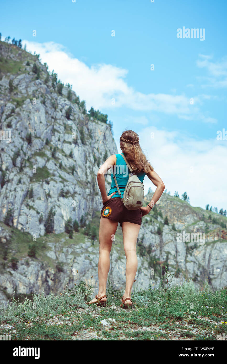 woman traveler with backpack looking at amazing mountains and river ...