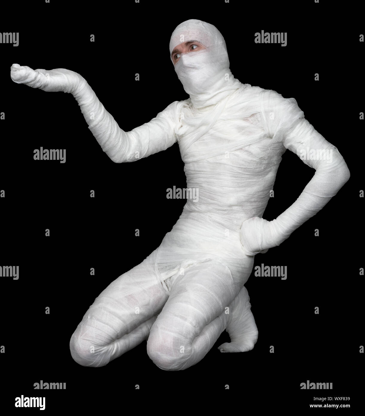 Mummy with extended hand sitting on black Stock Photo - Alamy
