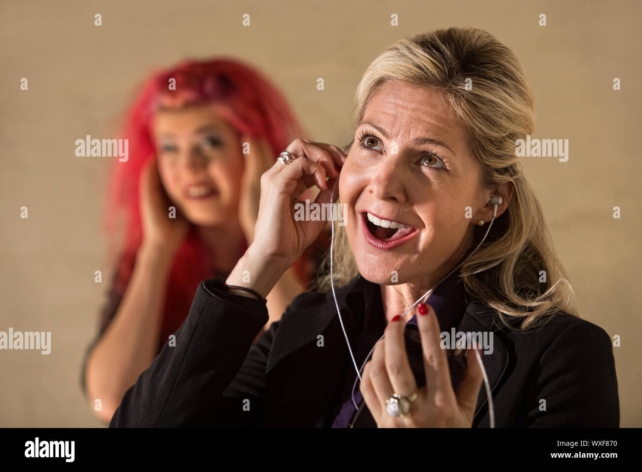 Goofy Caucasian lady with mp3 player and annoyed teenager Stock Photo ...