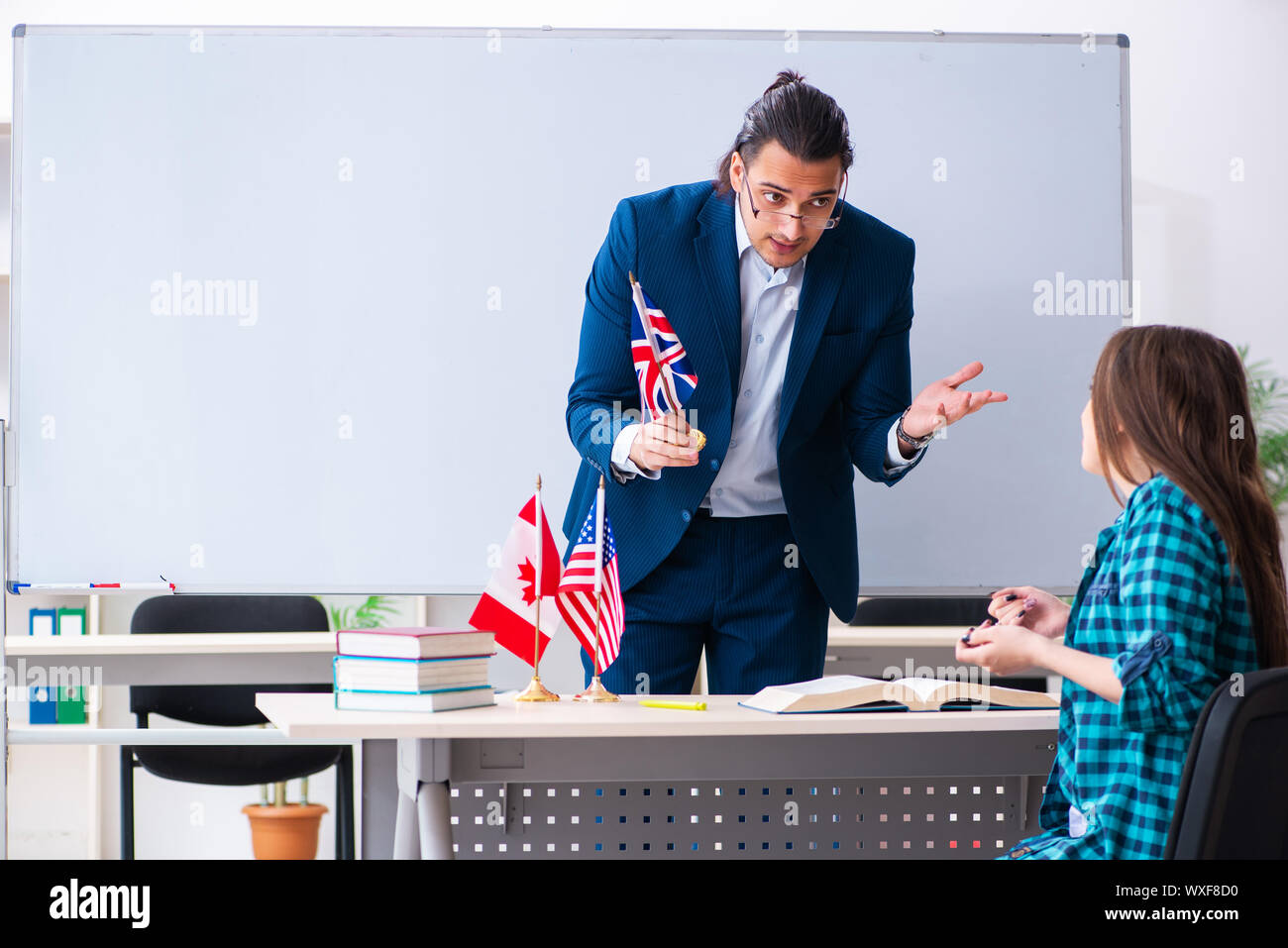 Male english teacher and female student in the classroom Stock Photo ...