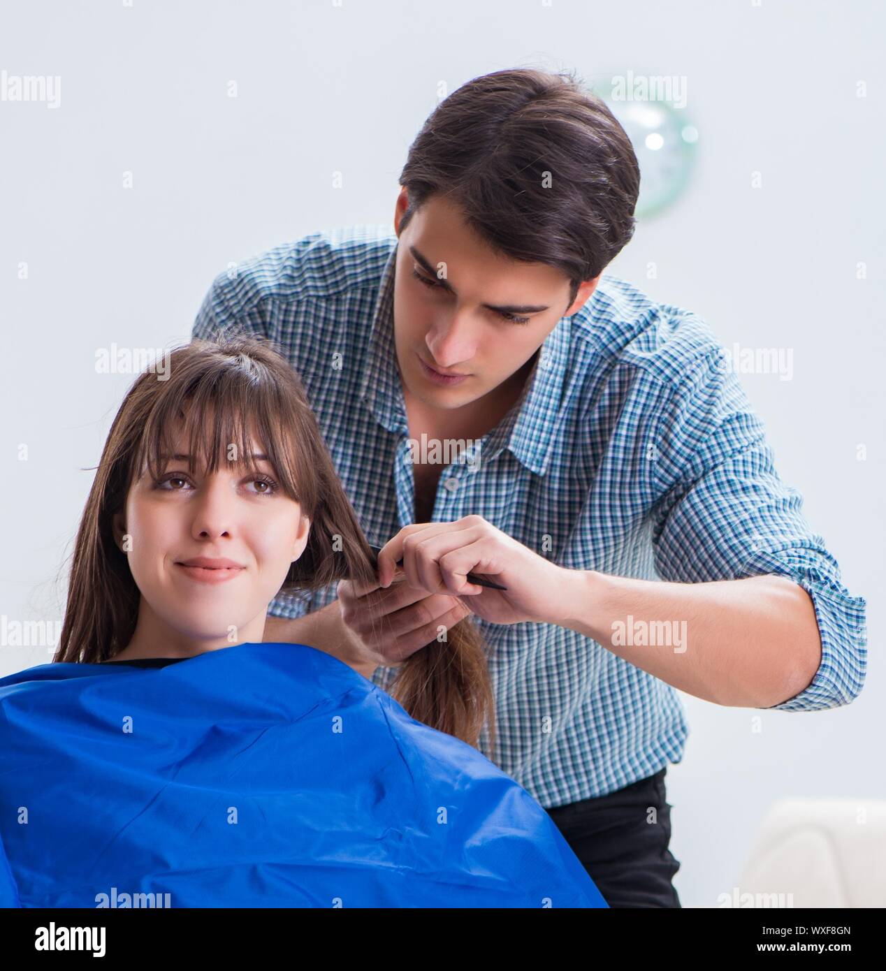Man male hairdresser doing haircut for woman Stock Photo - Alamy