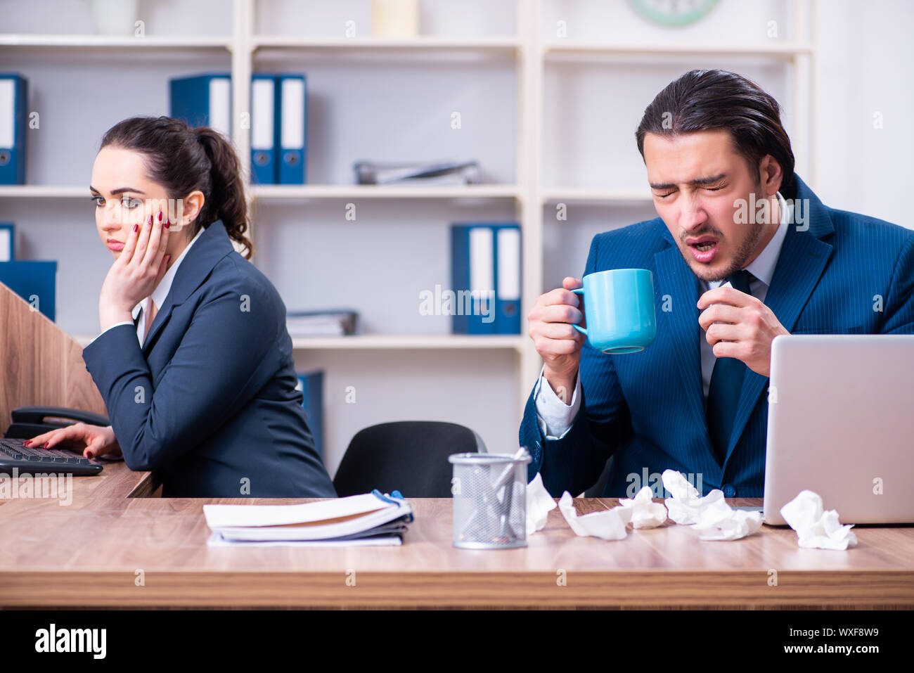 Two employees suffering at workplace Stock Photo - Alamy