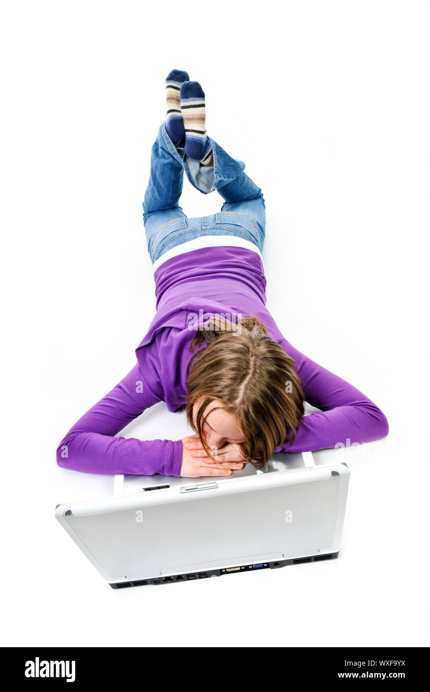 Tired young girl lying down asleep on laptop computer Stock Photo - Alamy
