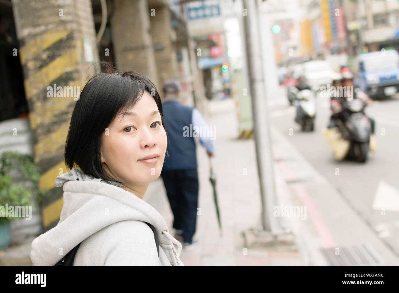 Mature Asian women in sport dress walk at modern street in Taipei ...