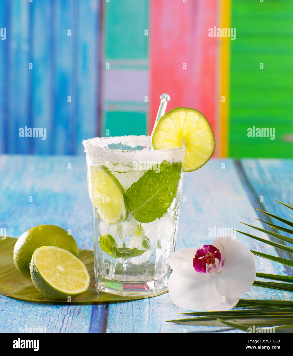 Cuban Mojito cocktail in tropical colorful house on blue wood with ...