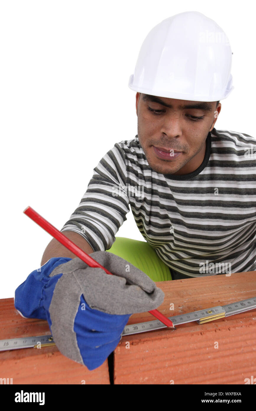 Bricklayer using a steel measure Stock Photo - Alamy