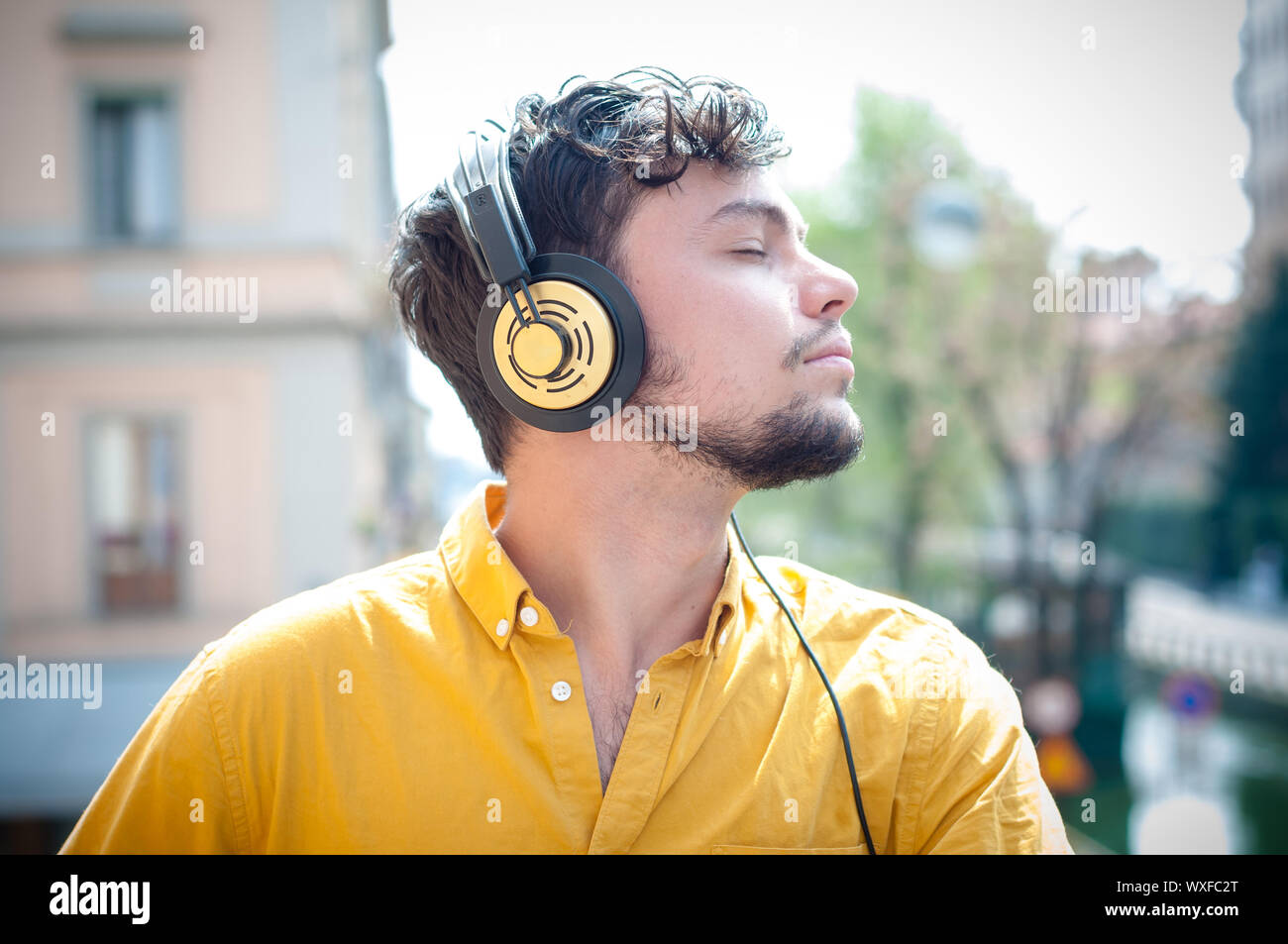 hipster young man listening to music on the balcony Stock Photo - Alamy
