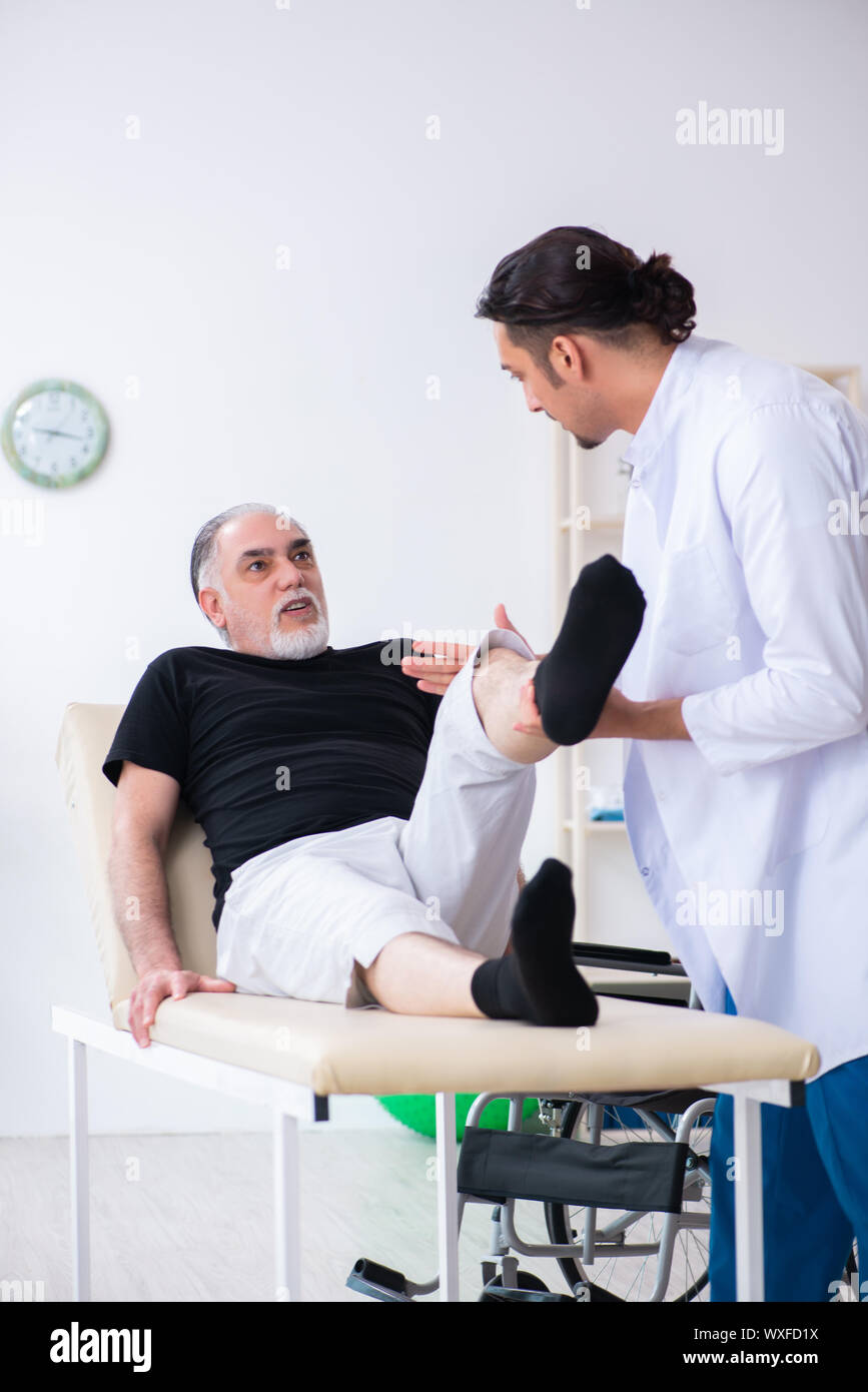 Old injured man visiting young doctor Stock Photo - Alamy