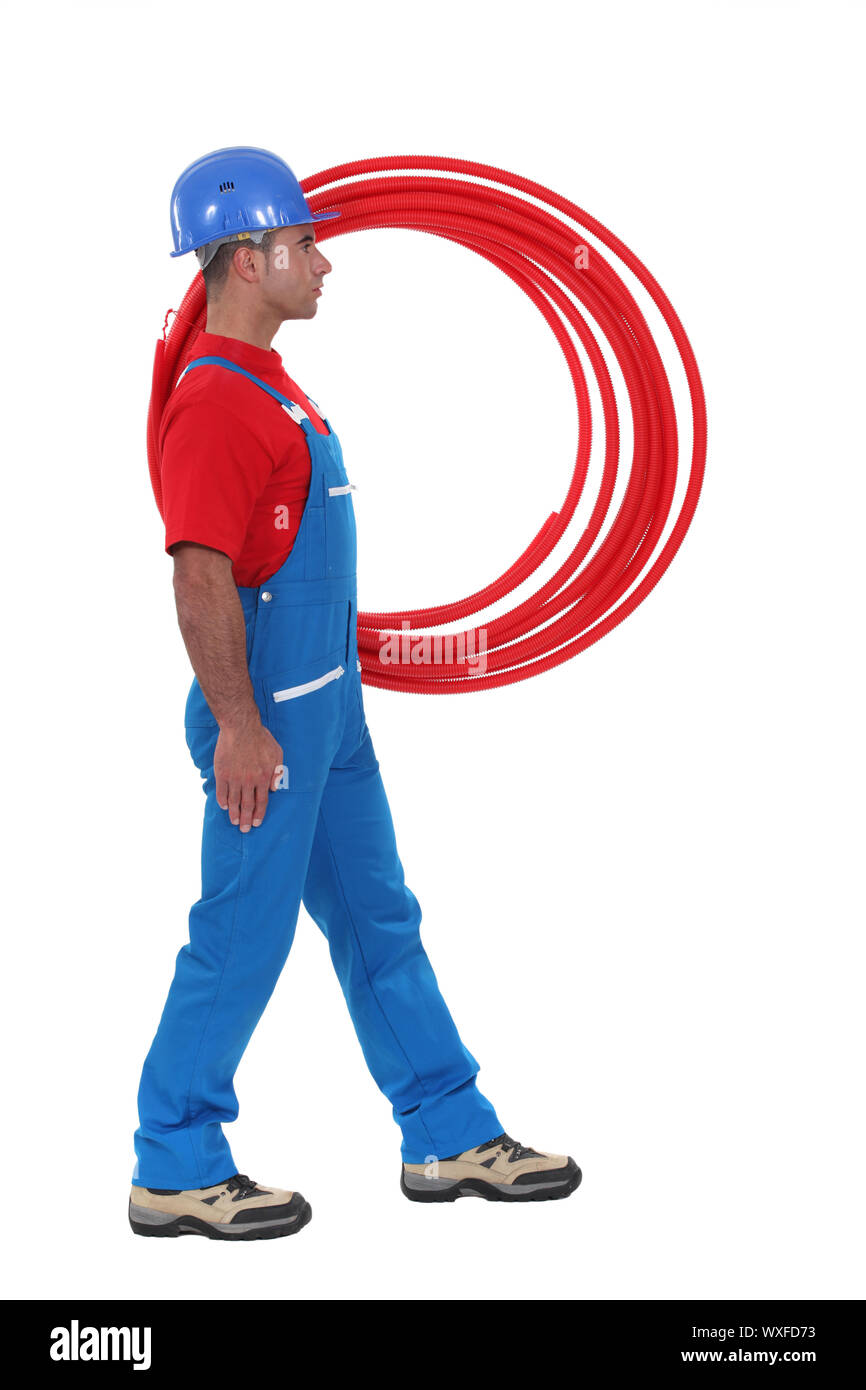 Plumber carrying pipes Stock Photo - Alamy
