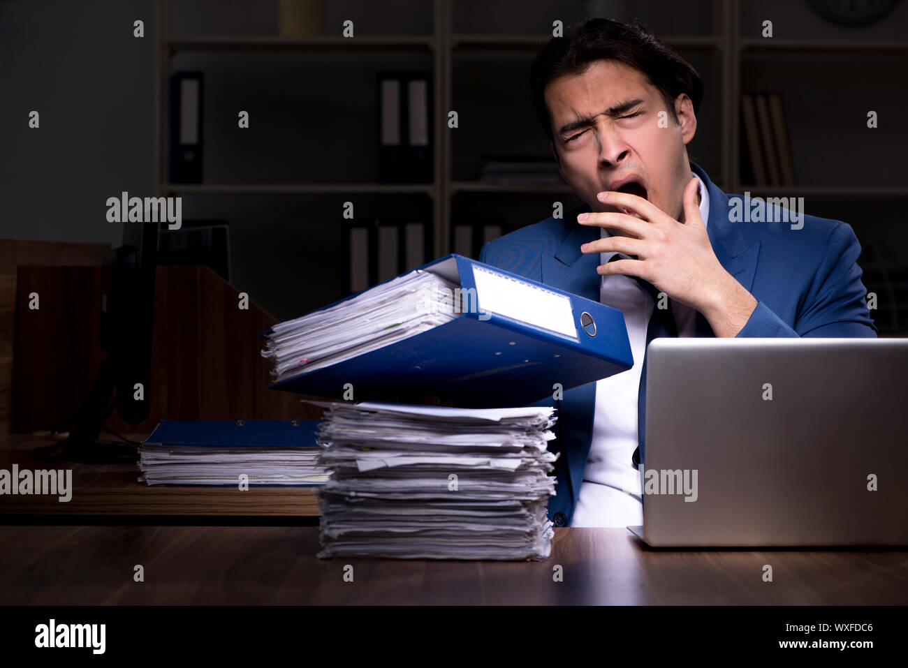 Young male employee working night in the office Stock Photo - Alamy