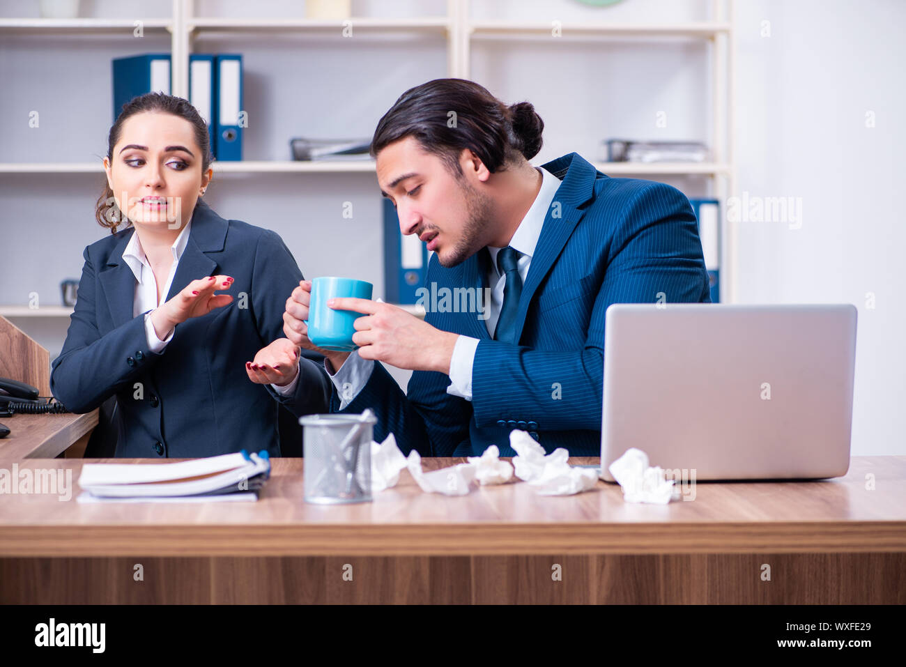 Two employees suffering at workplace Stock Photo - Alamy