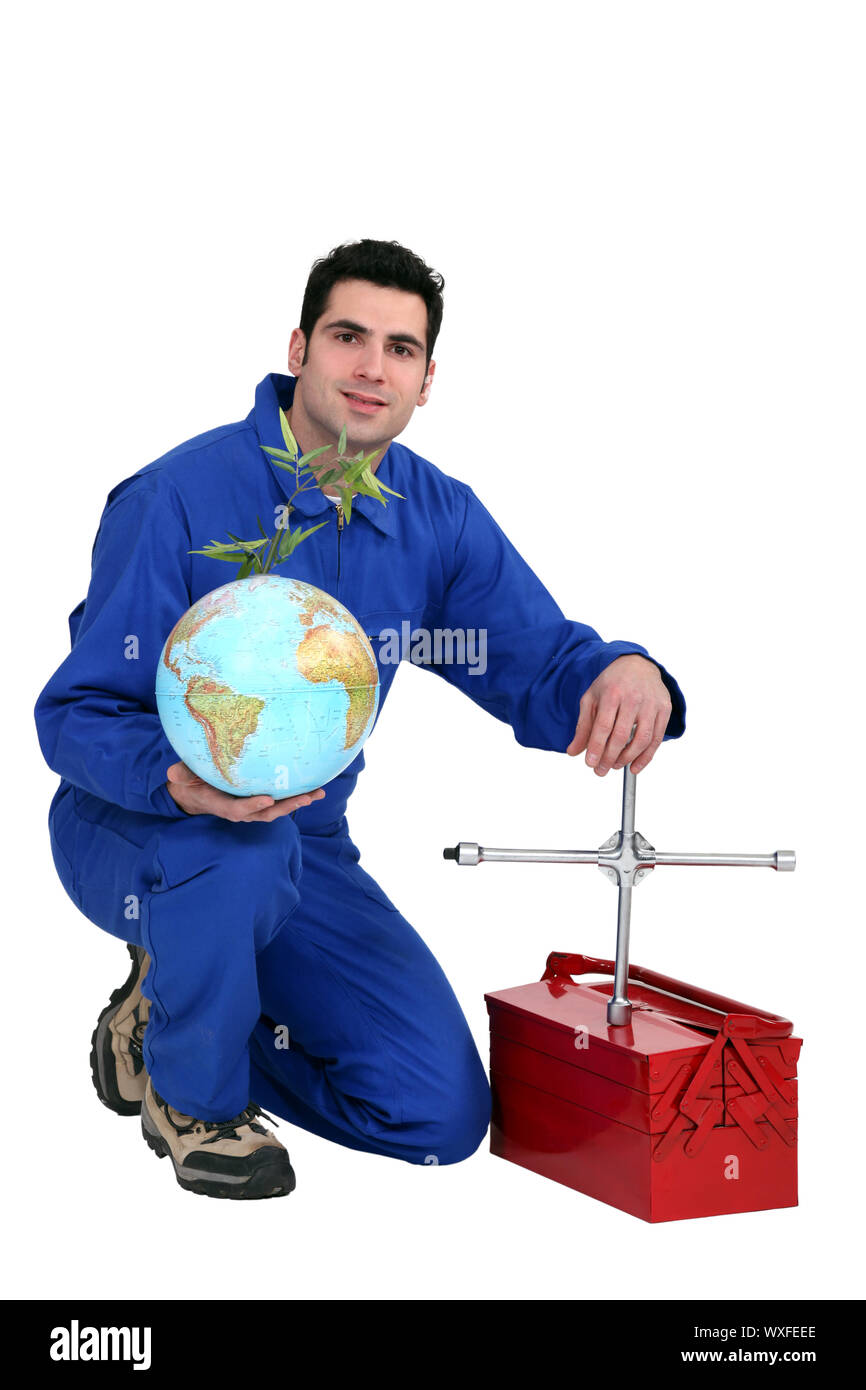 Mechanic kneeling with globe and wrench in hand Stock Photo - Alamy