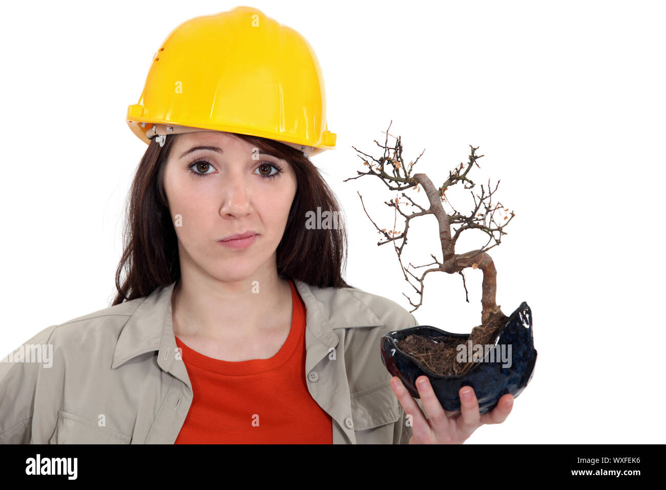 A female construction worker holding a dead plant Stock Photo - Alamy