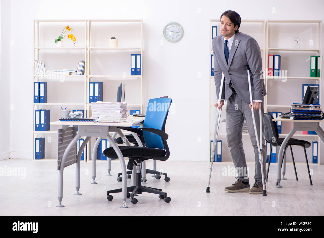 Leg injured male employee working in the office Stock Photo - Alamy