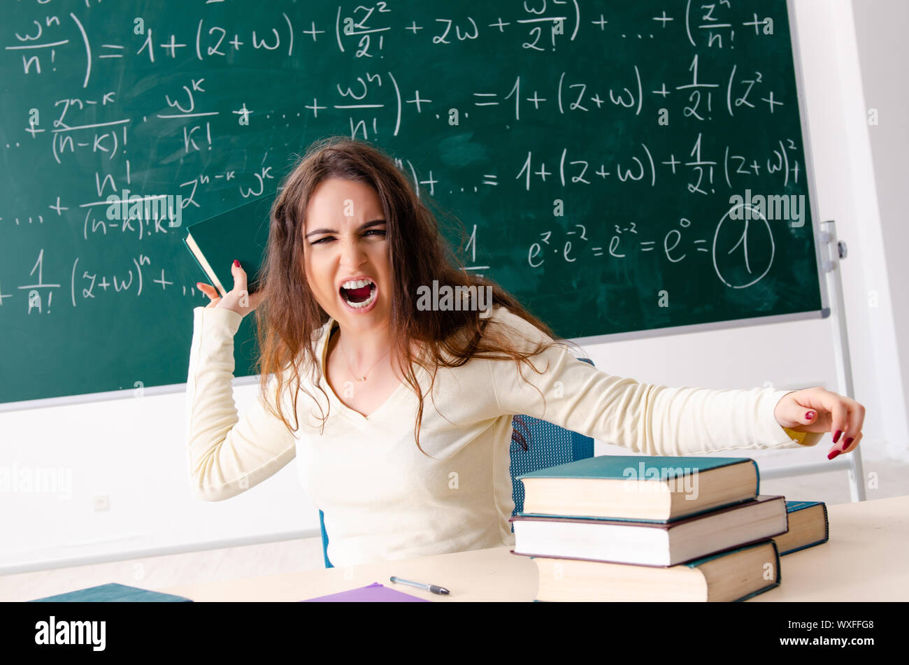 Young female math teacher in front of chalkboard Stock Photo - Alamy