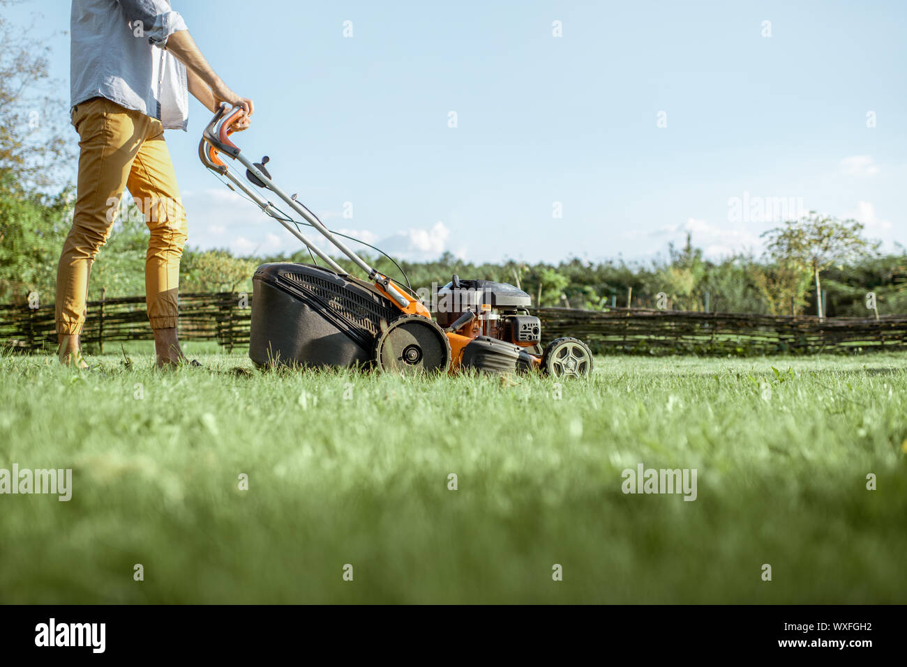 Man pushing lawnmower hi-res stock photography and images - Alamy