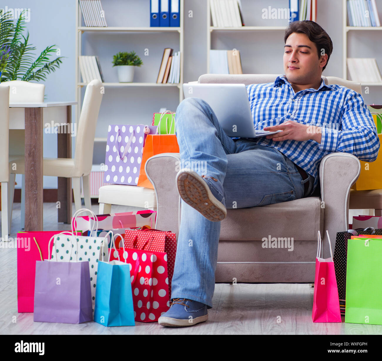 Young man after excessive shopping at home Stock Photo - Alamy