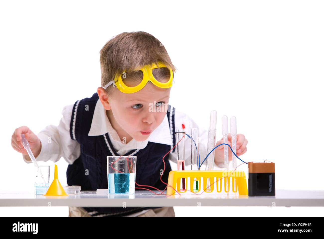 Crazy scientist. Young boy performing experiments with battery and ...