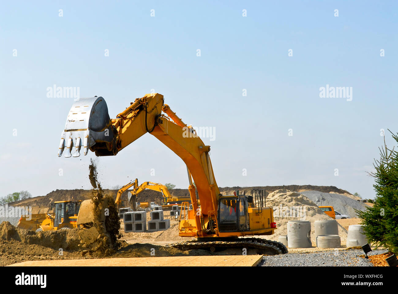 Yellow bulldozer machines digging and moving earth at construction site ...