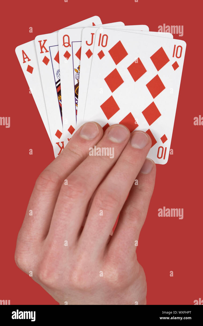 Playing cards single suit in hand on red Stock Photo - Alamy