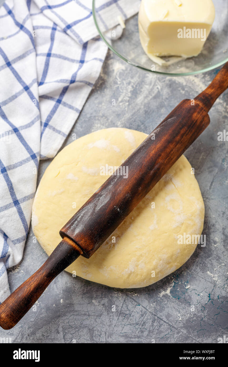 Dough is rolled out with rolling pin for the dough Stock Photo - Alamy