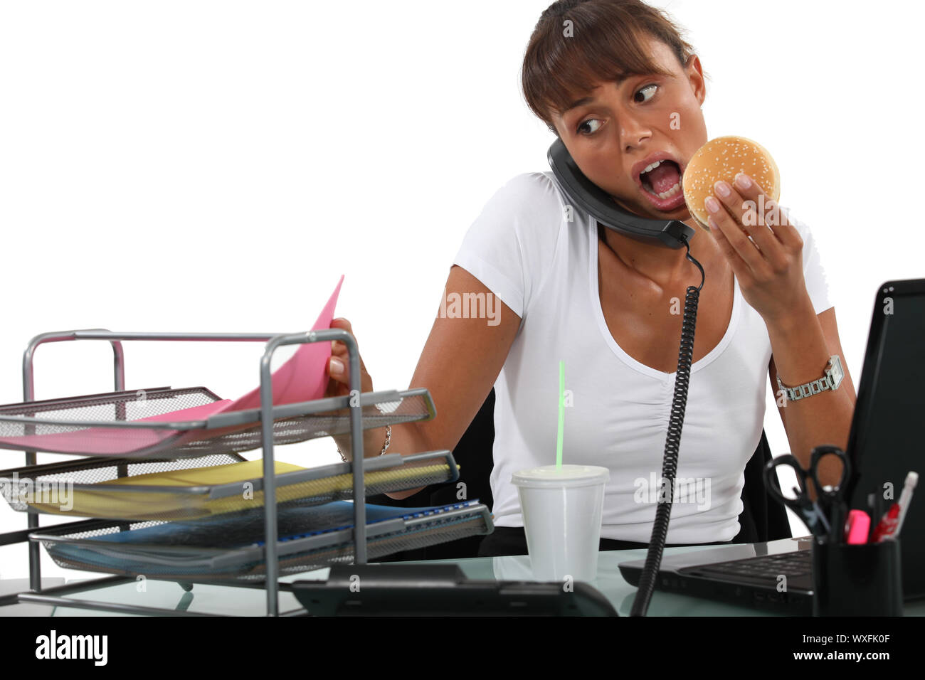 Busy woman eating at her desk Stock Photo - Alamy