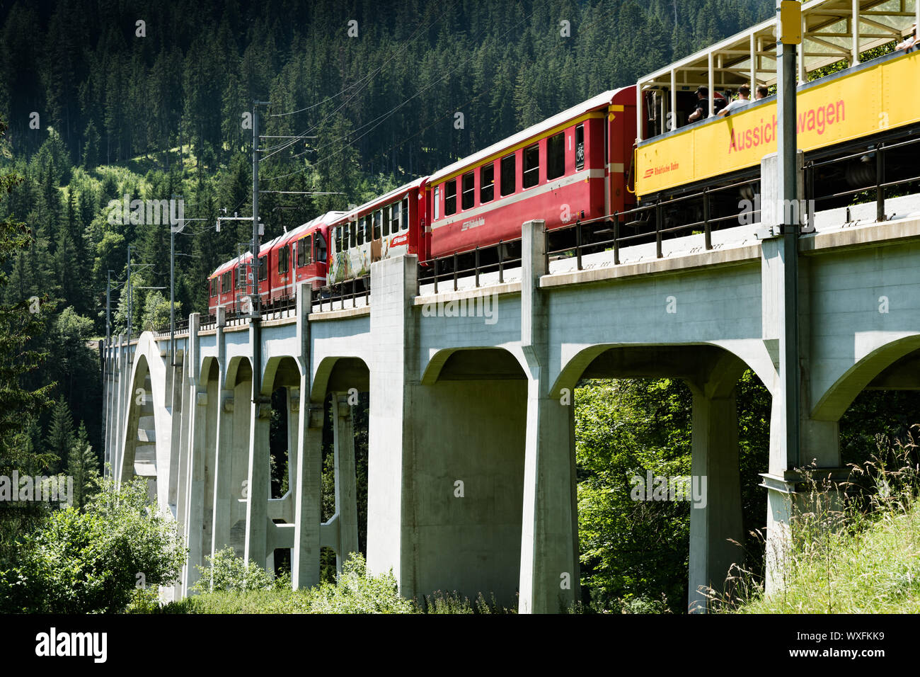 narrow gauge train crosses a long viaduct across a deep ravine in the ...