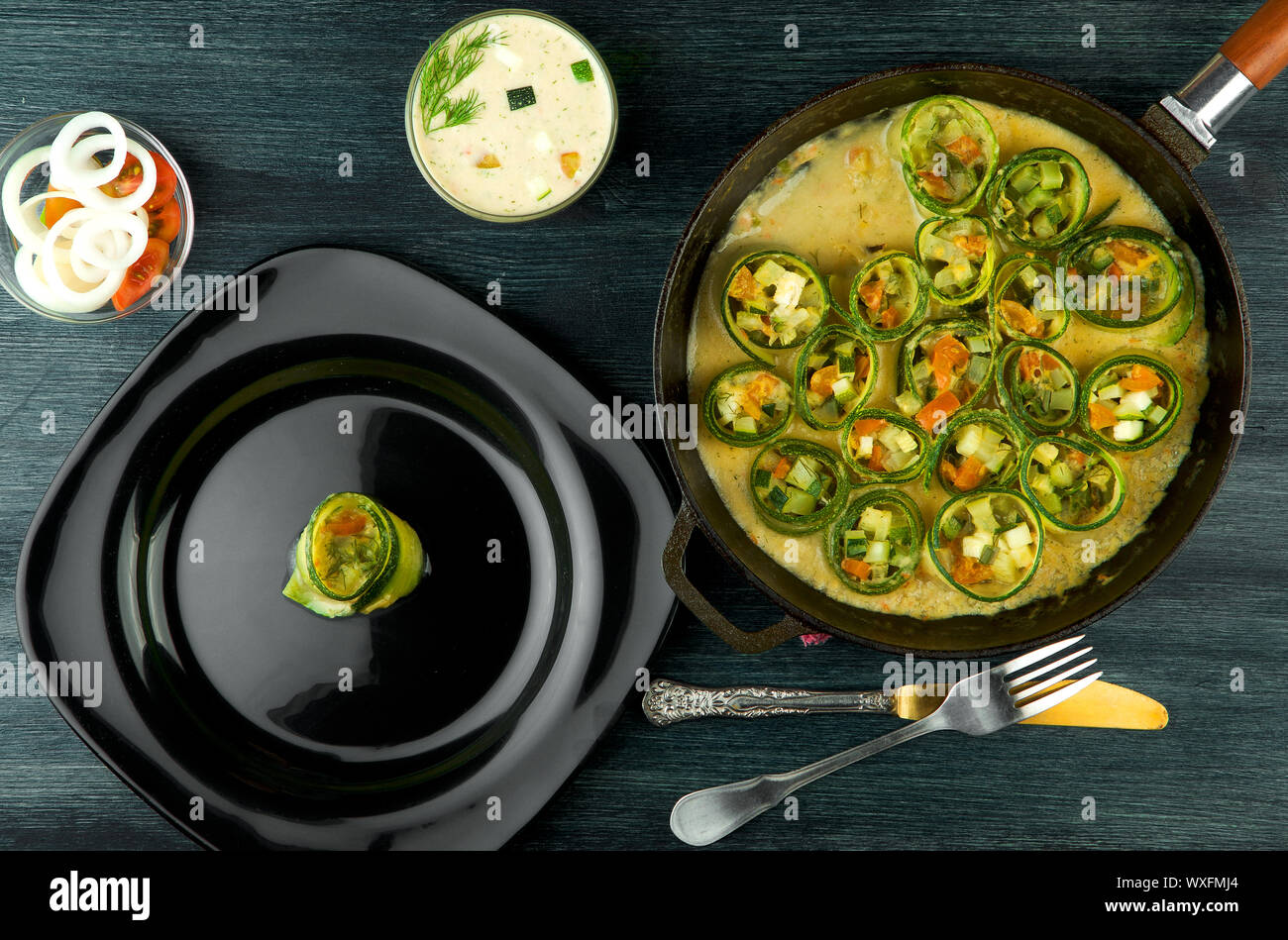 Zucchini in the background. Fried young sliced courgettes in a pan on a ...