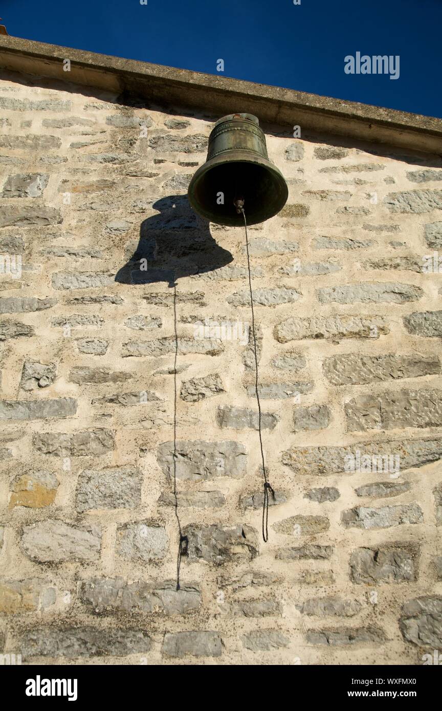 old green bell on a stone wall Stock Photo - Alamy
