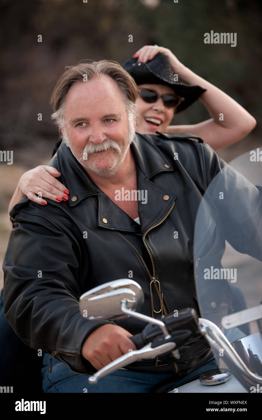 Fun couple riding a white motorcycle outside Stock Photo - Alamy