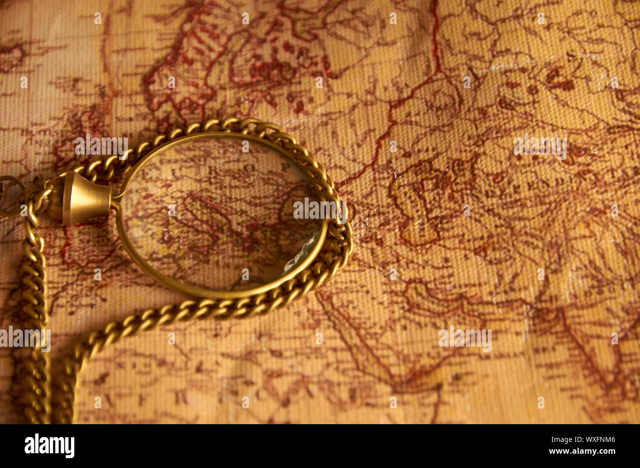 Old gold magnifying glass lying on a map Stock Photo - Alamy