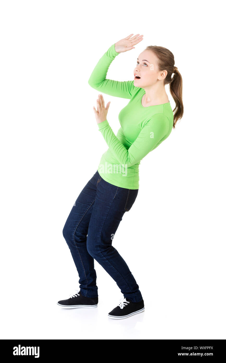 Scared young woman afraid of something above her, isolated on white ...