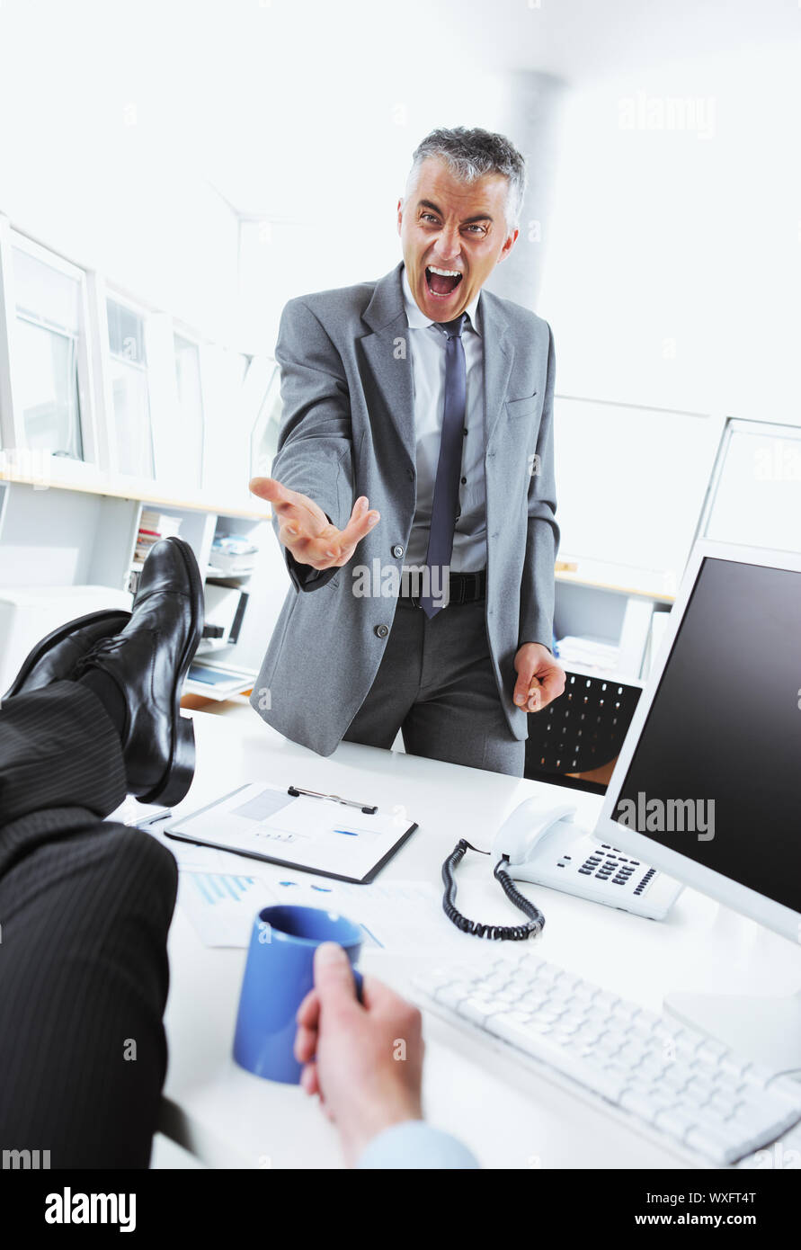 Business man relaxing at desk while his boss shouting angry Stock Photo ...