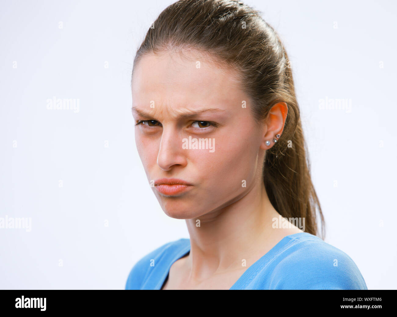 Portrait of a young woman scowling at you Stock Photo - Alamy