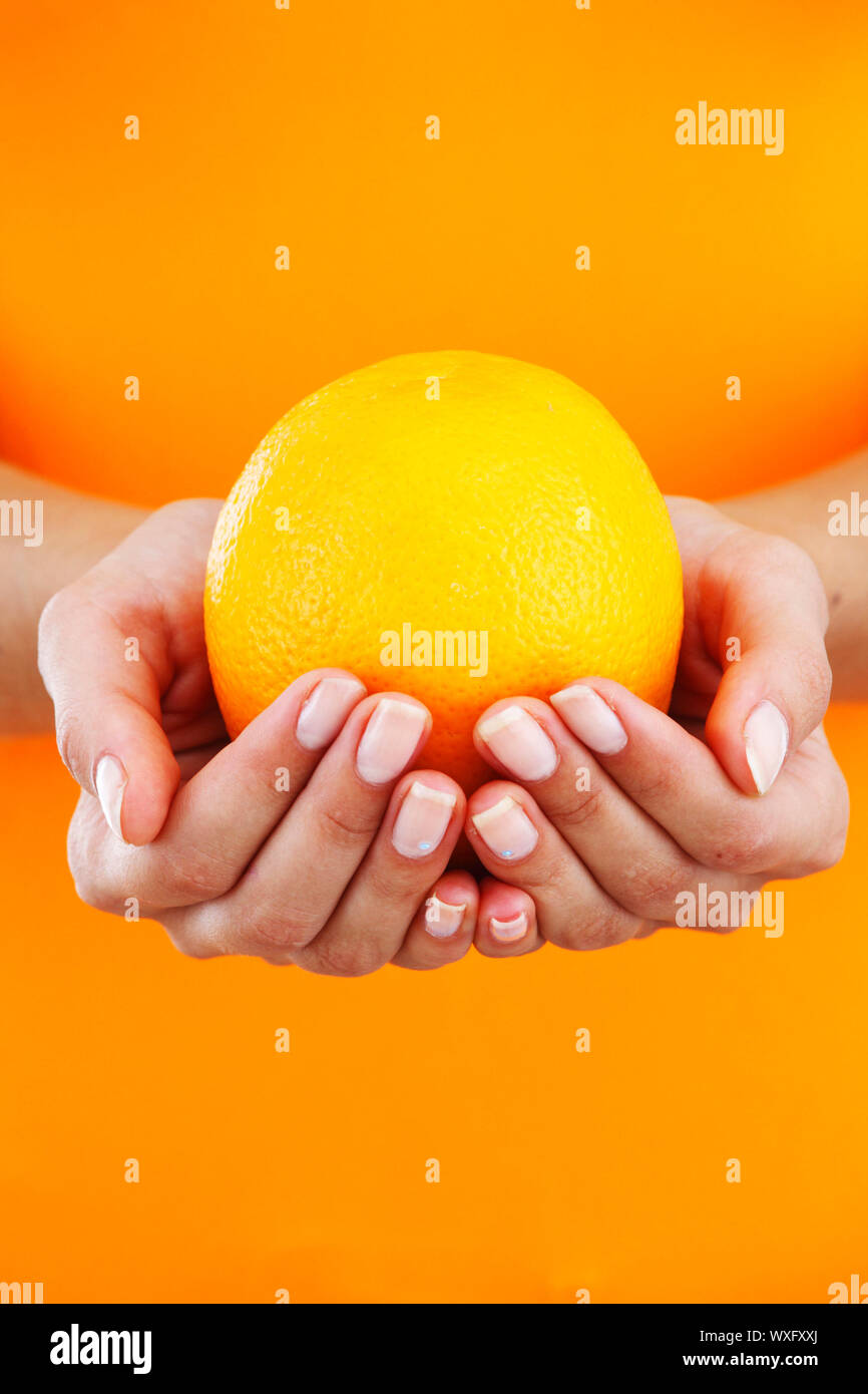 orange in woman hands close up Stock Photo - Alamy
