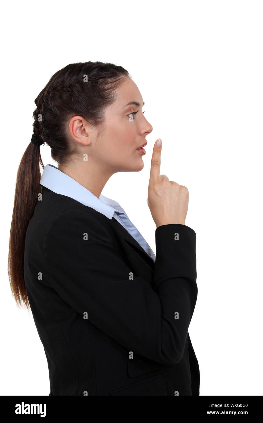 Woman holding her index finger to her lips Stock Photo - Alamy