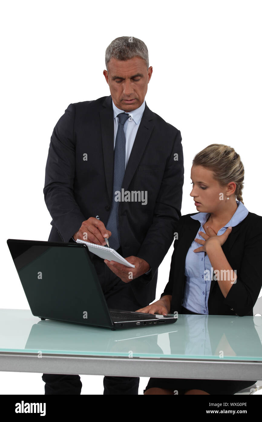 Boss handing note to young assistant Stock Photo - Alamy